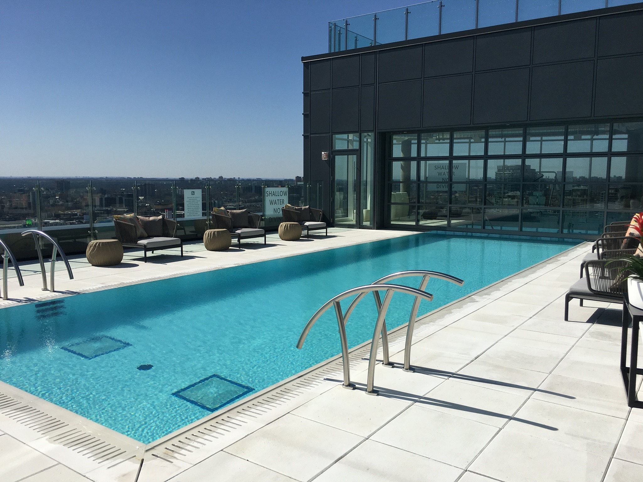 Rooftop swimming pool with clear blue water, surrounded by modern ...