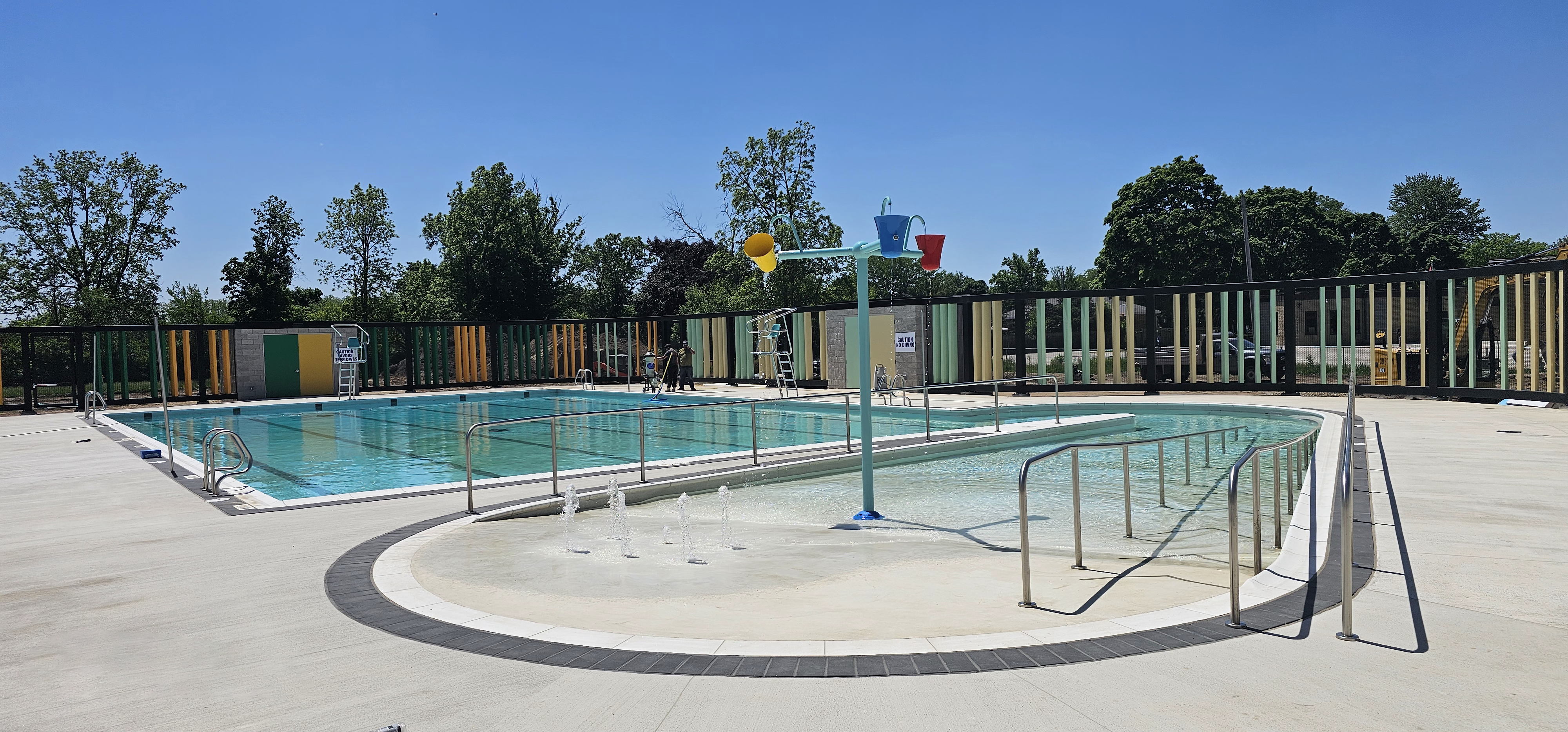 An outdoor lap and leisure pool on a sunny day. There is zero depth ...