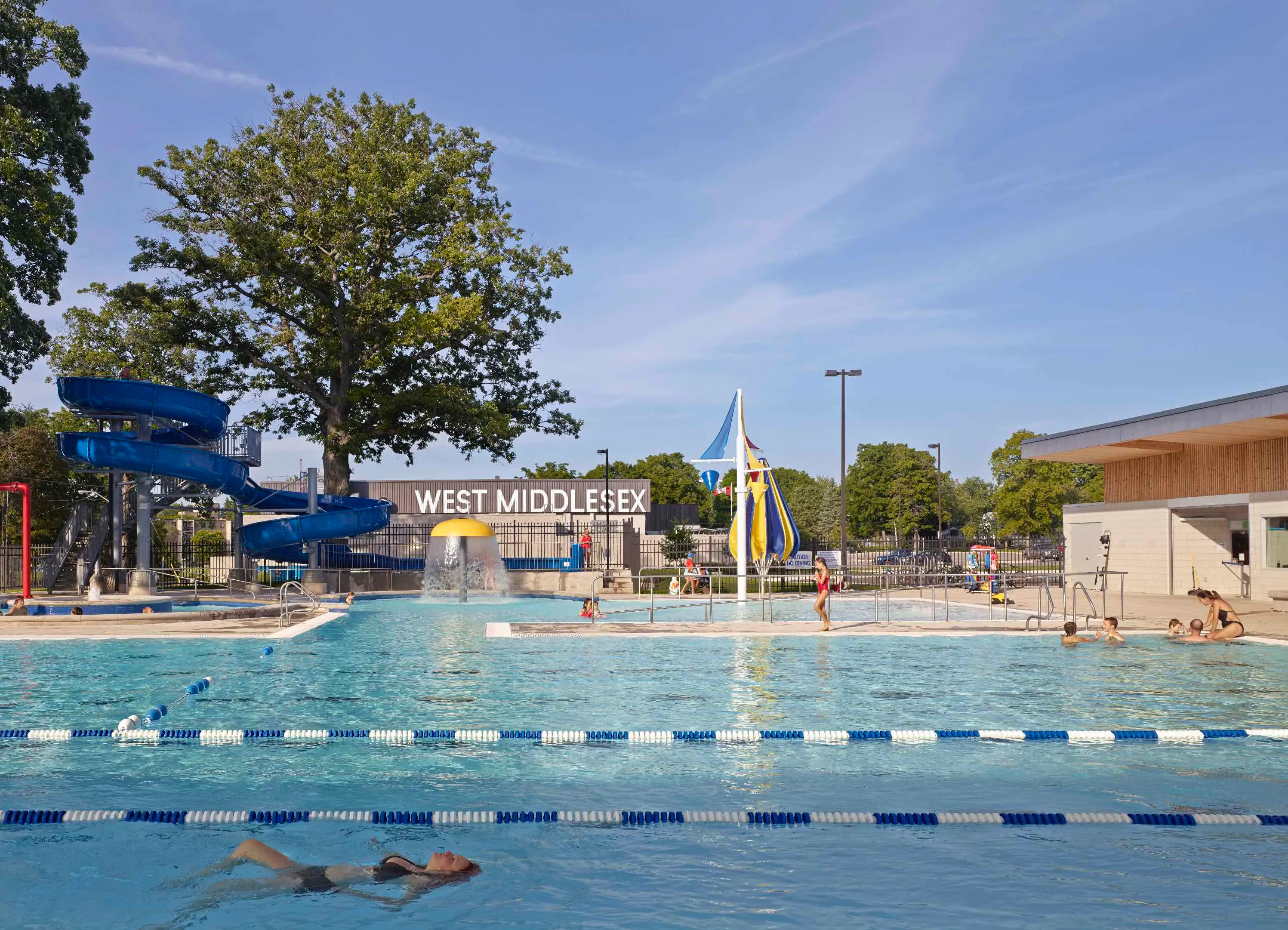 An outdoor swimming pool complex with a blue water slide, splash ...