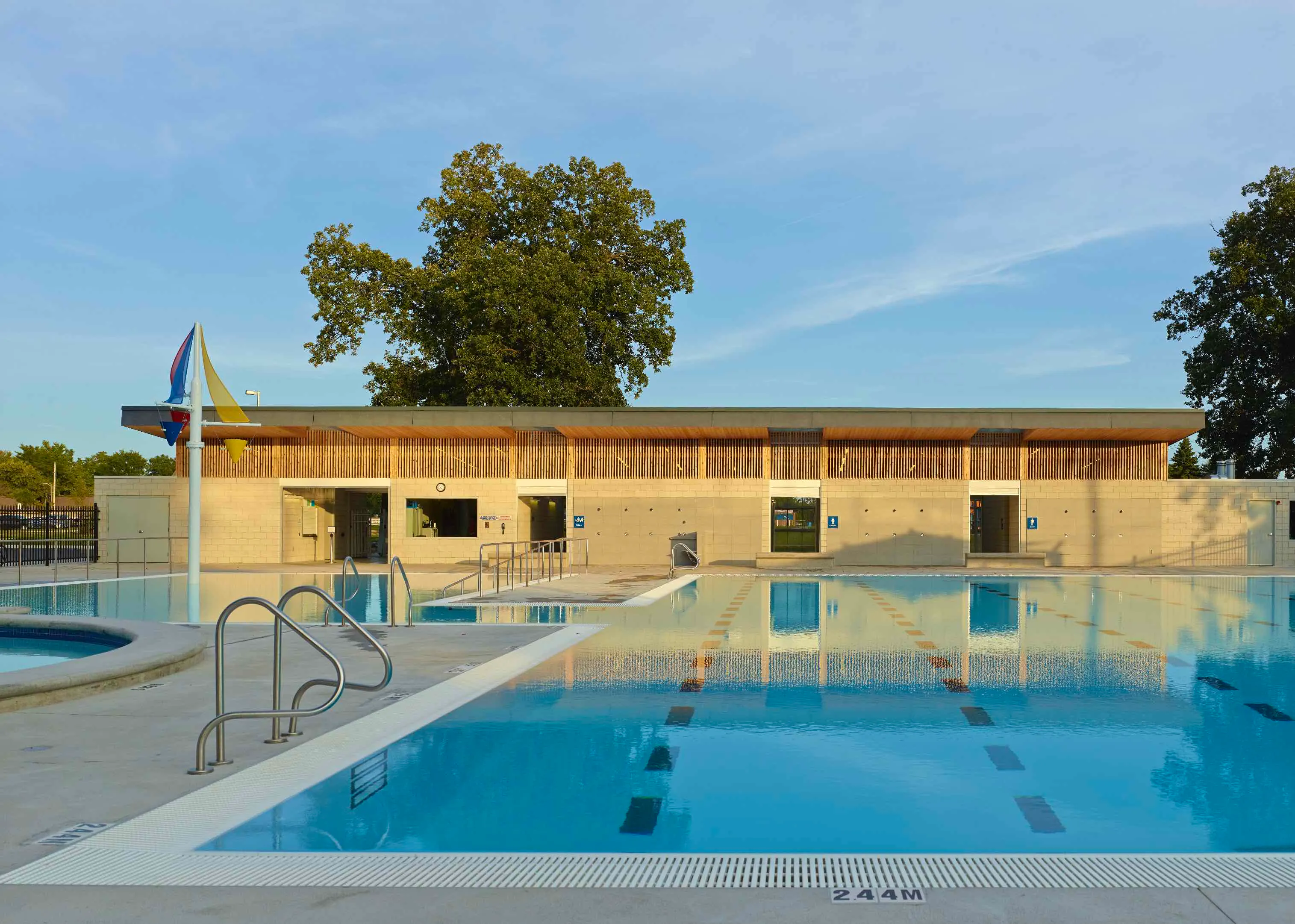 An outdoor swimming pool with lap lanes and a modern building in the ...