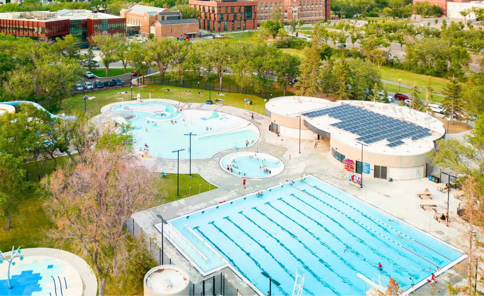 An aerial view of an outdoor pool complex with lap pools, recreational ...