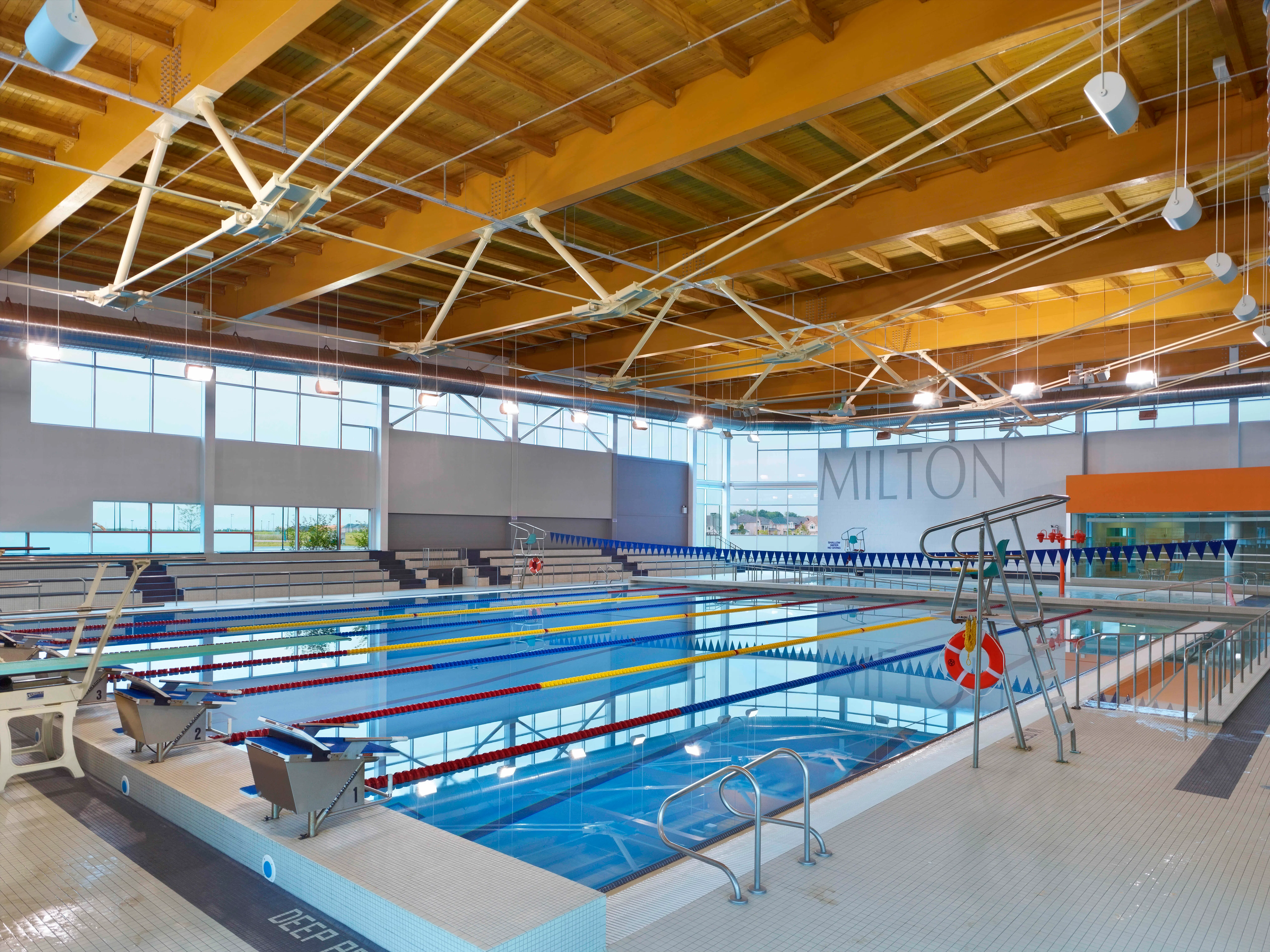 An indoor swimming facility with lap lanes, diving boards, and large ...