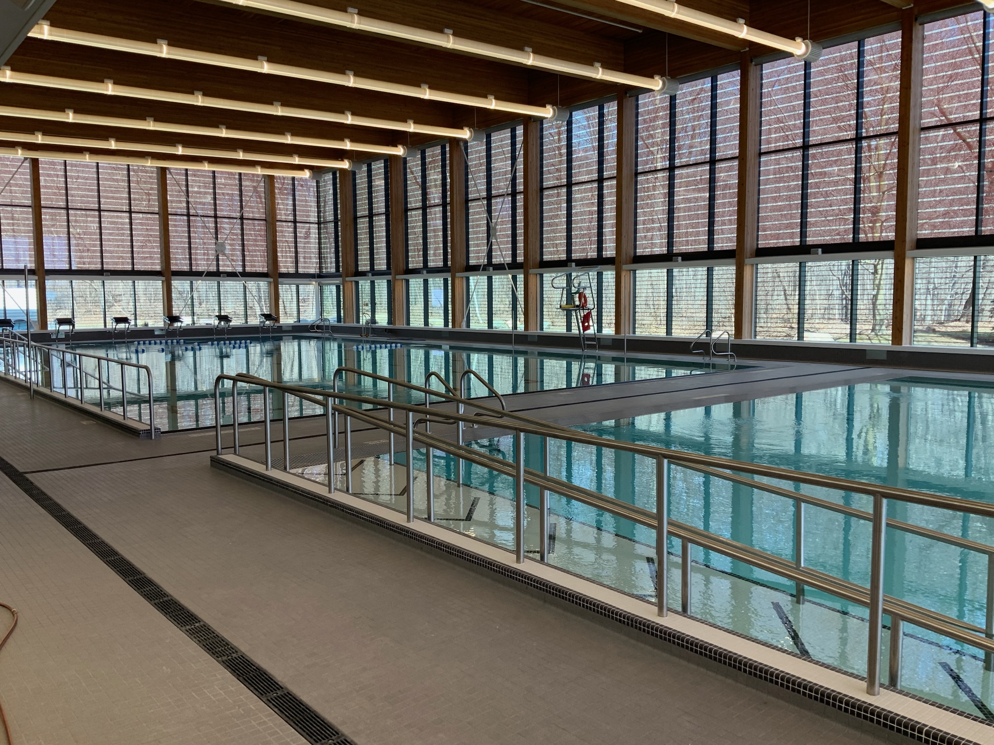 Indoor pools with an accessibility ramp, wood panelled ceiling and ...