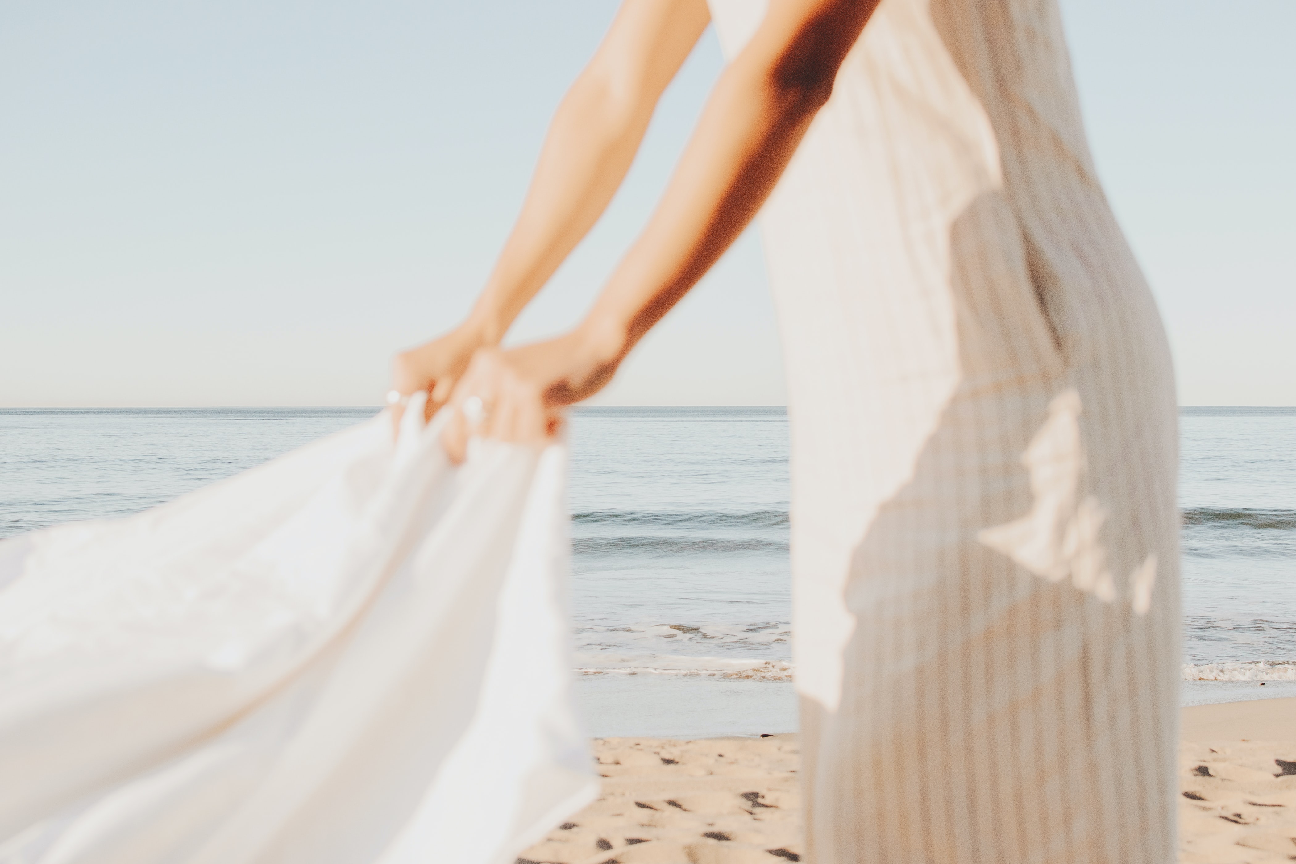 Woman holding linen cloth on a beach